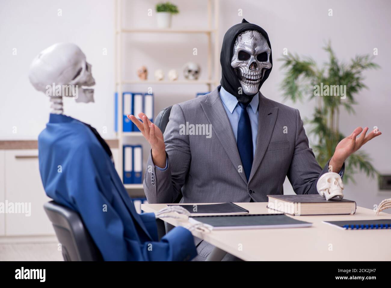 Funny business meeting with the devil and skeletons Stock Photo - Alamy