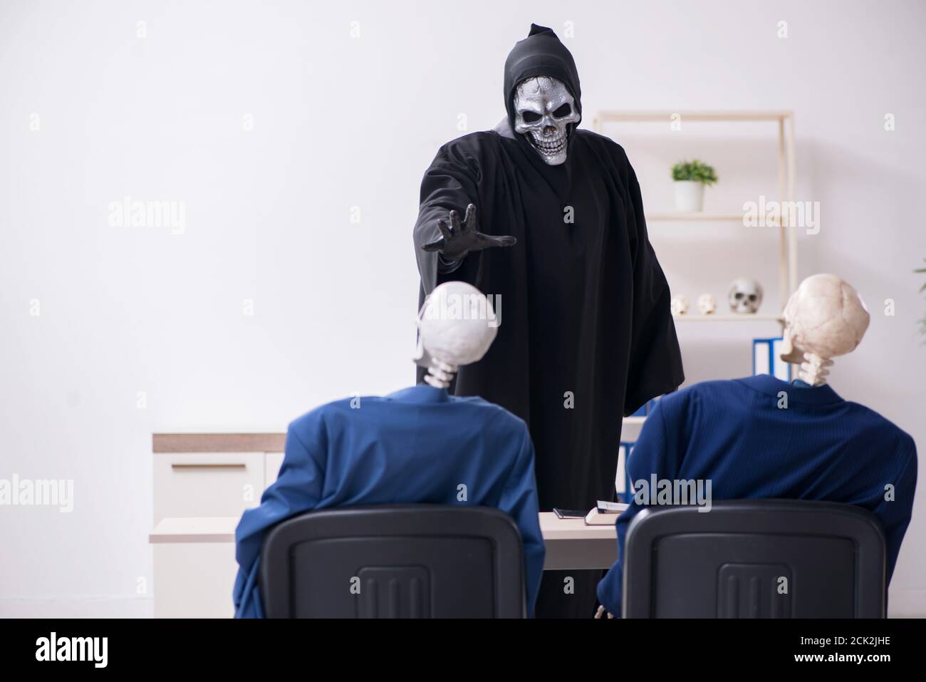 Funny business meeting with the devil and skeletons Stock Photo - Alamy