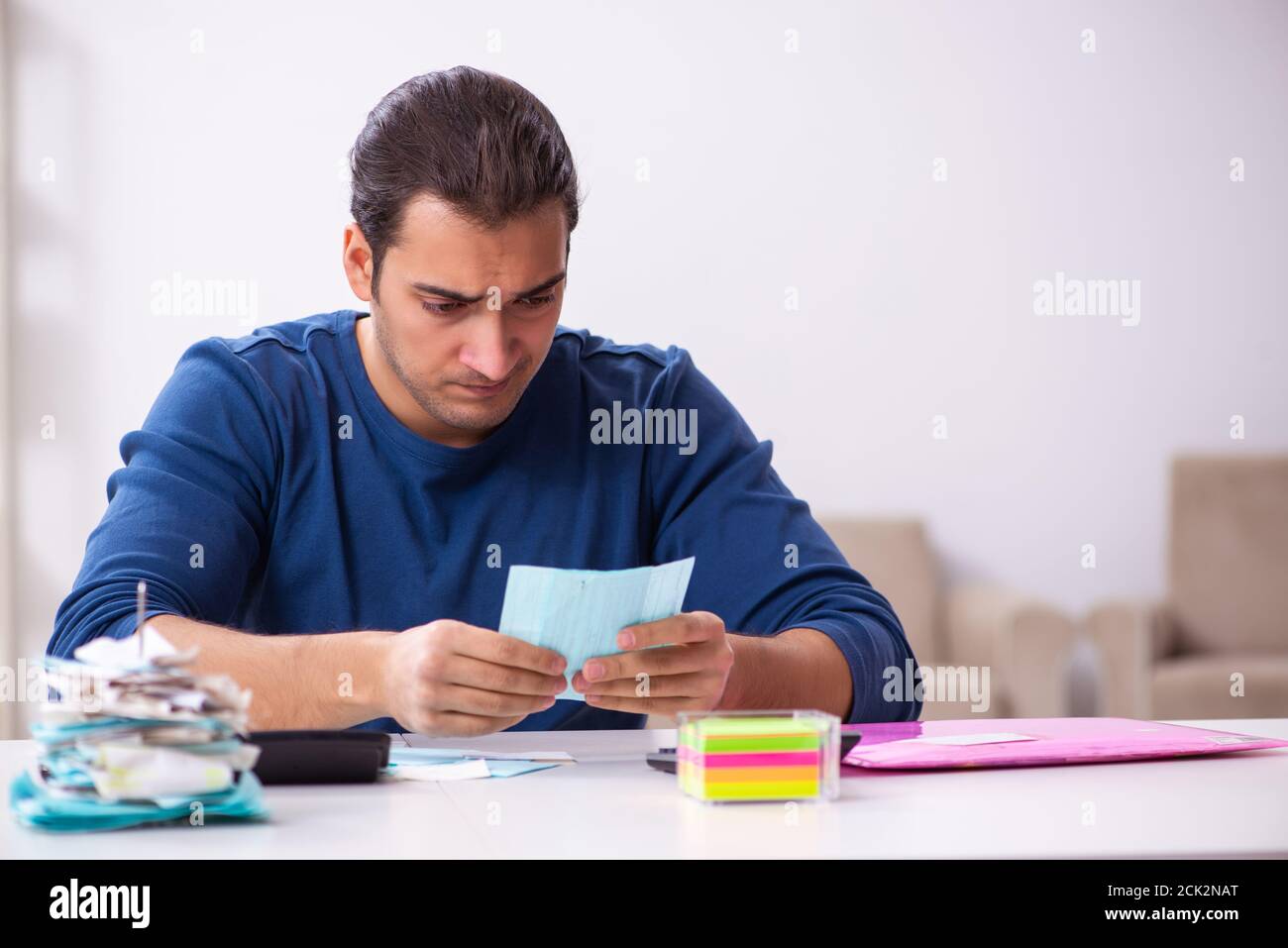 Young man in the budget planning concept Stock Photo - Alamy