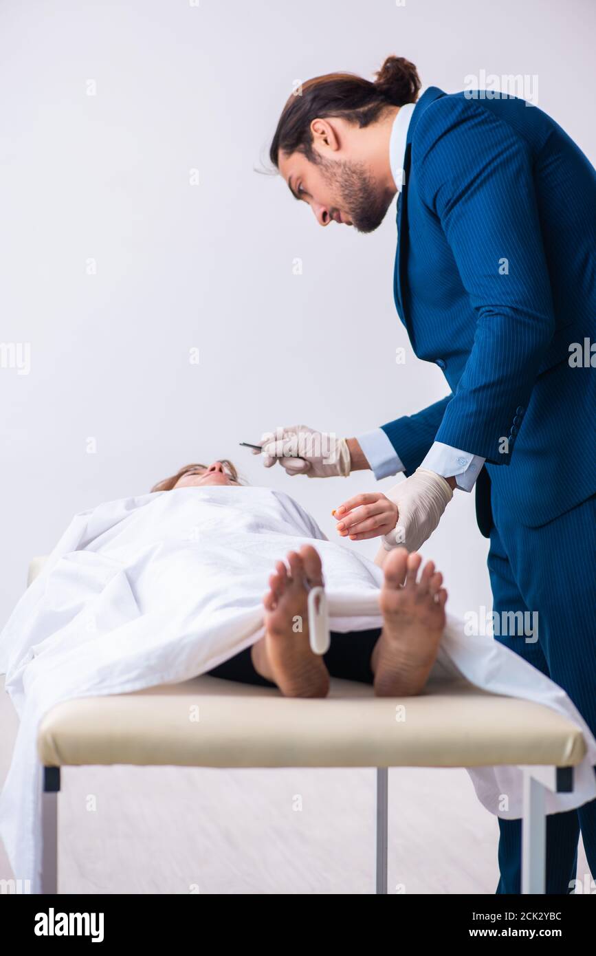 Police coroner examining dead body in morgue Stock Photo - Alamy