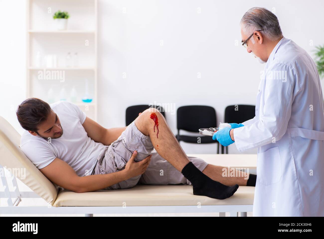 Leg injured man visiting doctor in first aid concept Stock Photo - Alamy