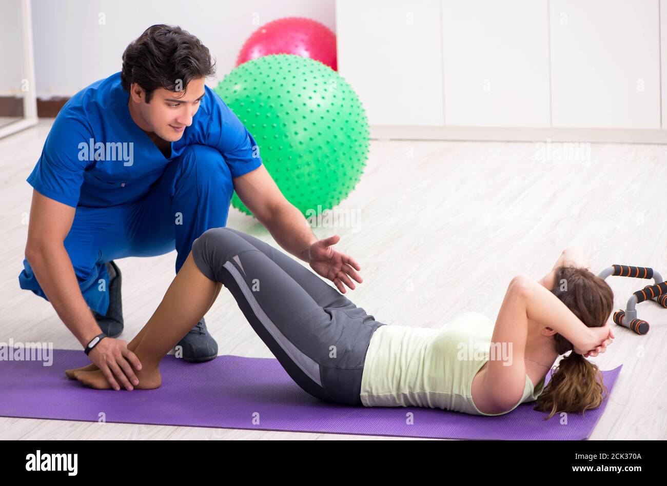 The fitness instructor helping sportsman during exercise Stock Photo ...