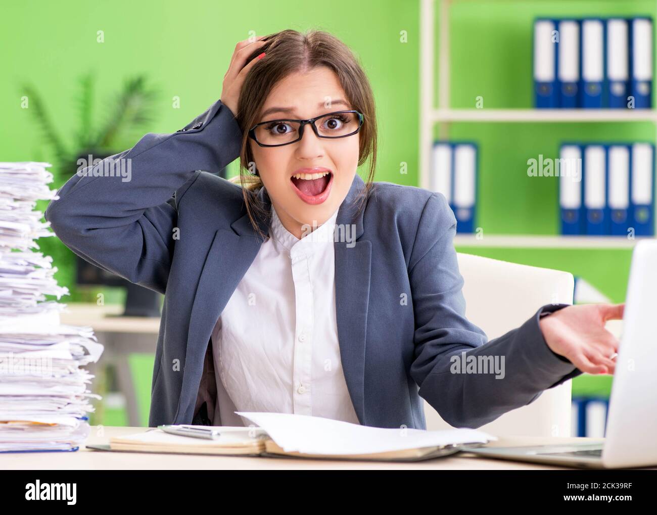 The young female employee very busy with ongoing paperwork Stock Photo ...