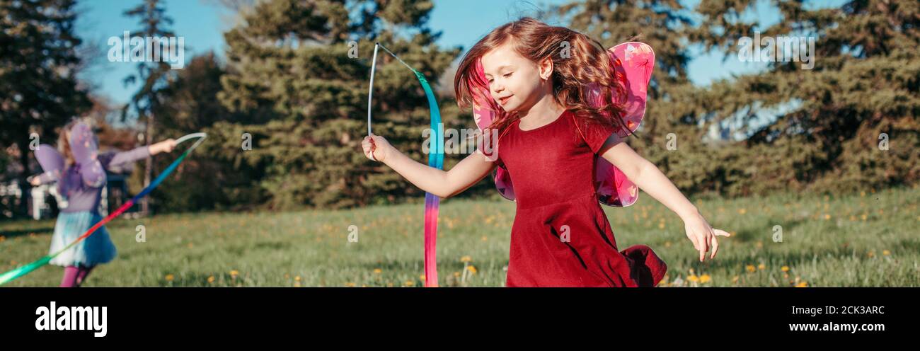 Happy children girls playing with ribbons in park. Cute adorable kids ...