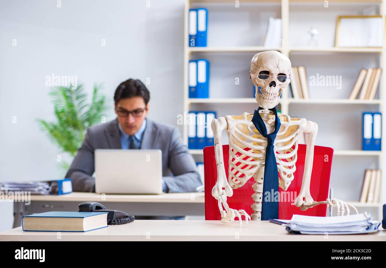 The businessman working with skeleton in office Stock Photo - Alamy