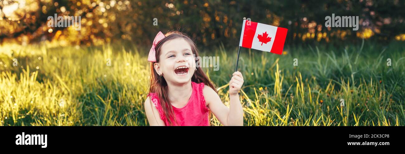 Happy Caucasian girl holding Canadian flag. Smiling child holding ...