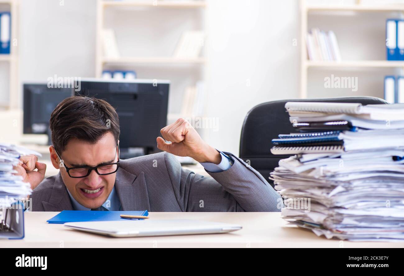 The overloaded with work employee under paperwork burden Stock Photo ...