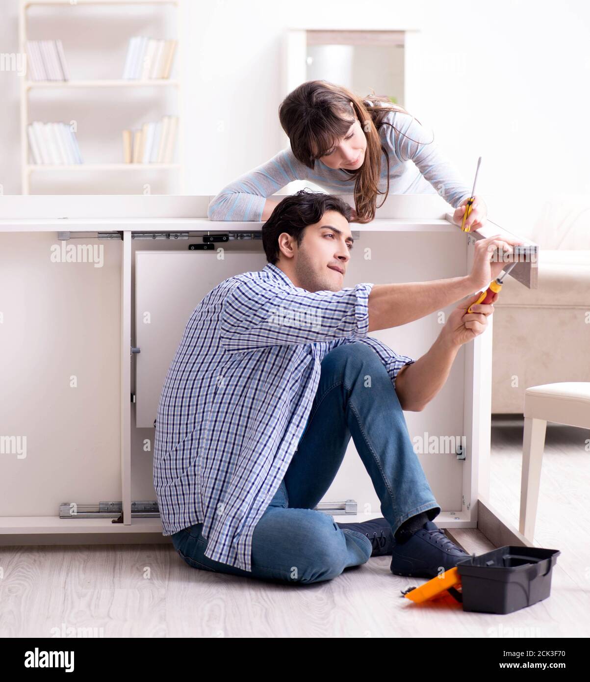The husband repairing broken table at home Stock Photo - Alamy