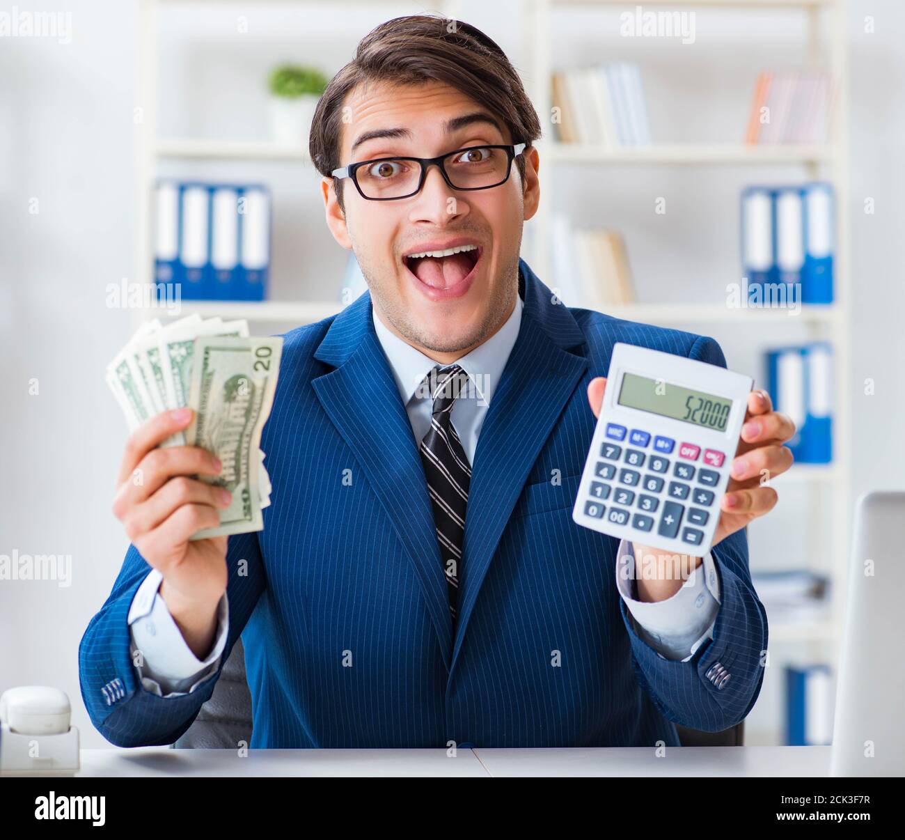 The accountant calculating dollars with calculator in office Stock ...