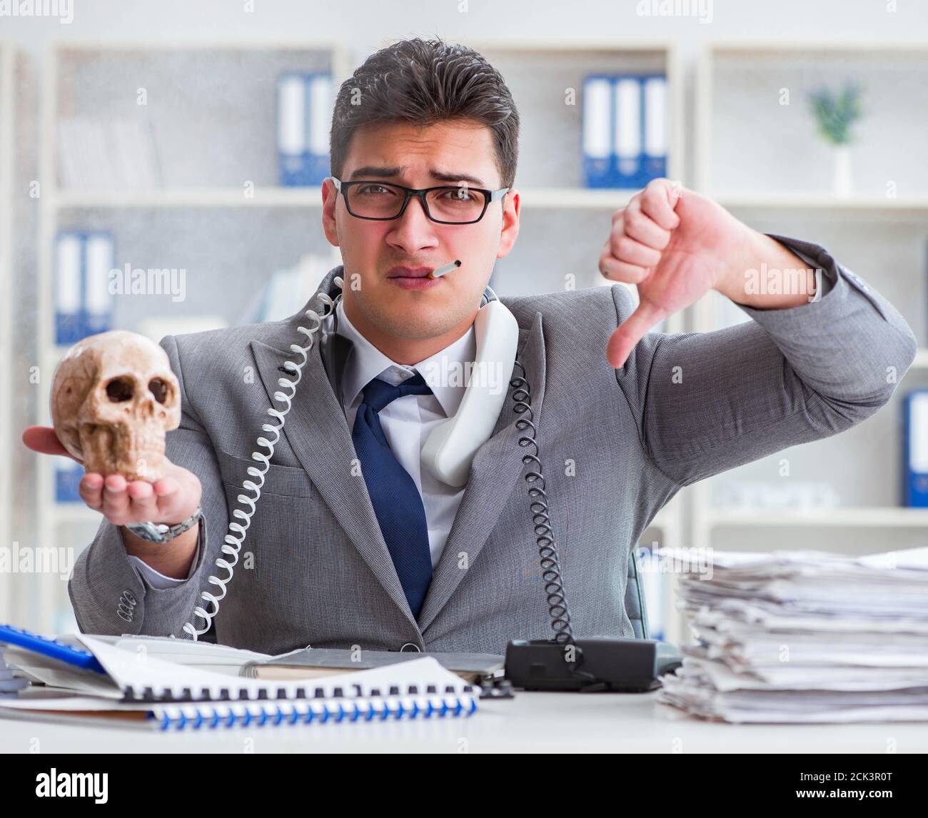 The businessman in the office smoking holding human skull Stock Photo ...