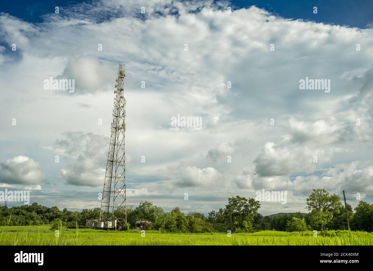 Telecommunications tower in a large green field under the beautiful sky ...