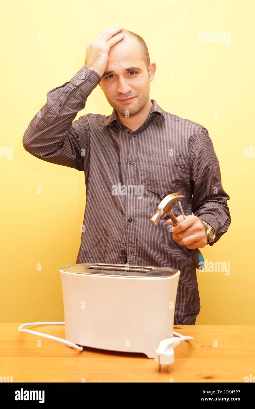 Male trying to repair a broken toaster Stock Photo - Alamy