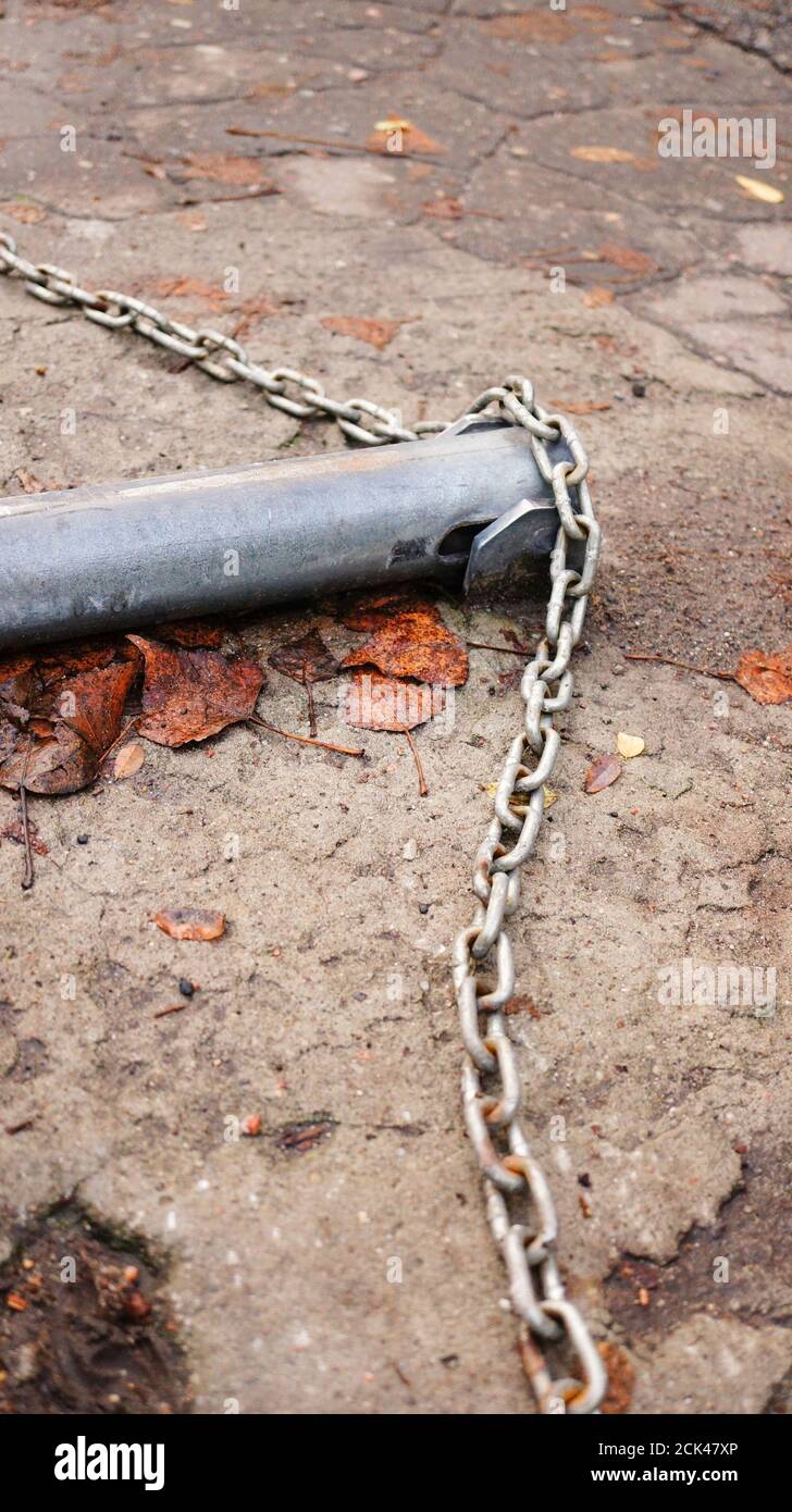 Vertical closeup shot of metal pole and chain lying on the ground Stock ...