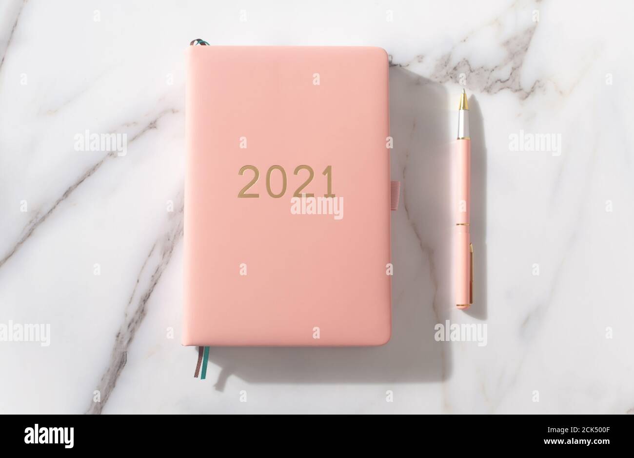 Pink coral colored diary for the year 2021, pen. Marble background ...