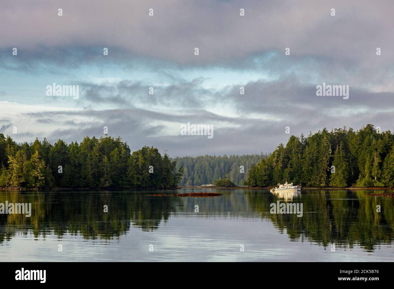 The sun rises over the Broken Islands in Pacific Rim National Park ...