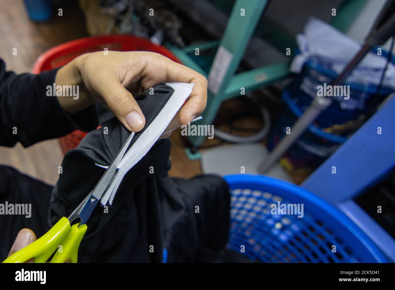 Female worker hand cutting lining paper on staff uniform on Garment ...