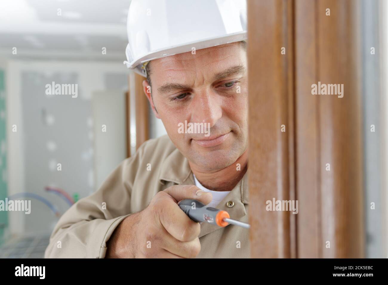 professional locksmith installing or repairing a lock Stock Photo - Alamy