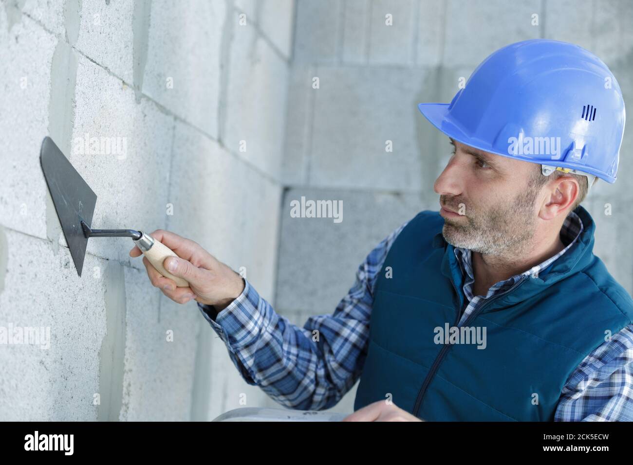 portrait of a man plastering concrete wall Stock Photo - Alamy