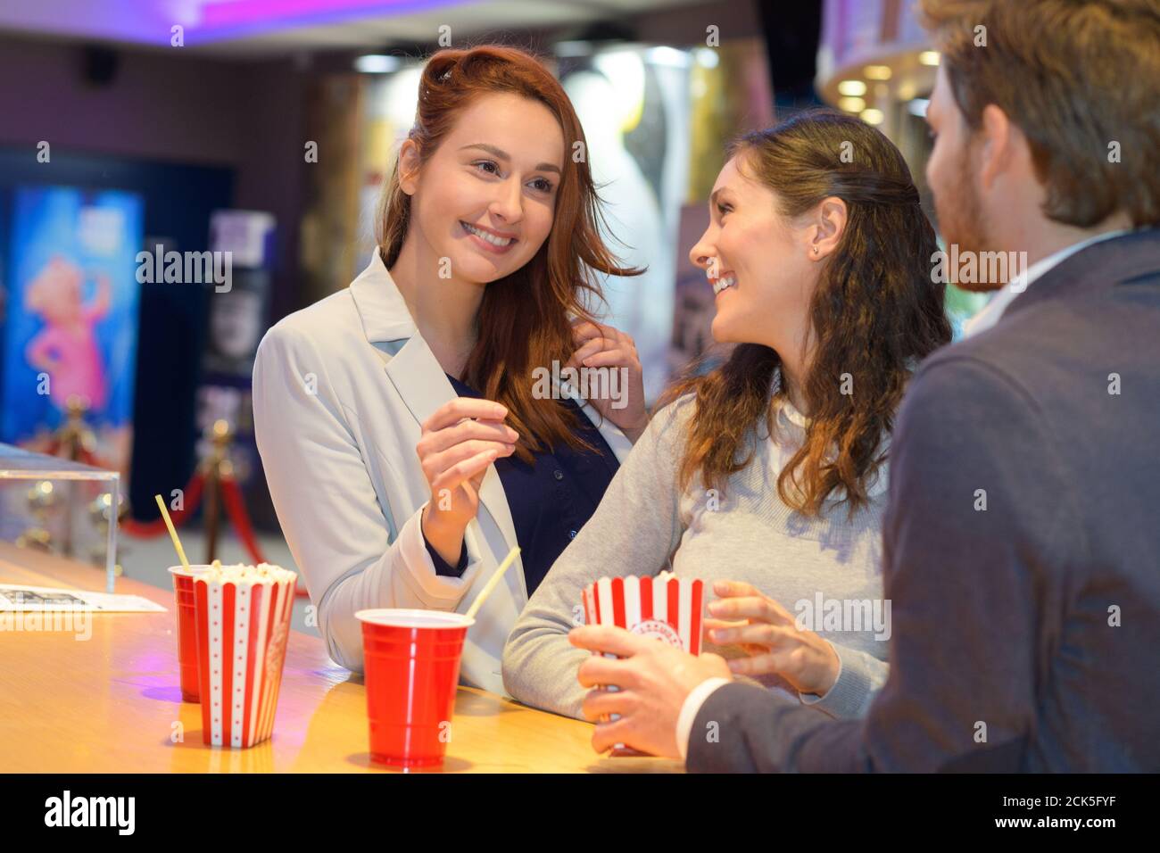 friends talking in the cinema lobby Stock Photo - Alamy