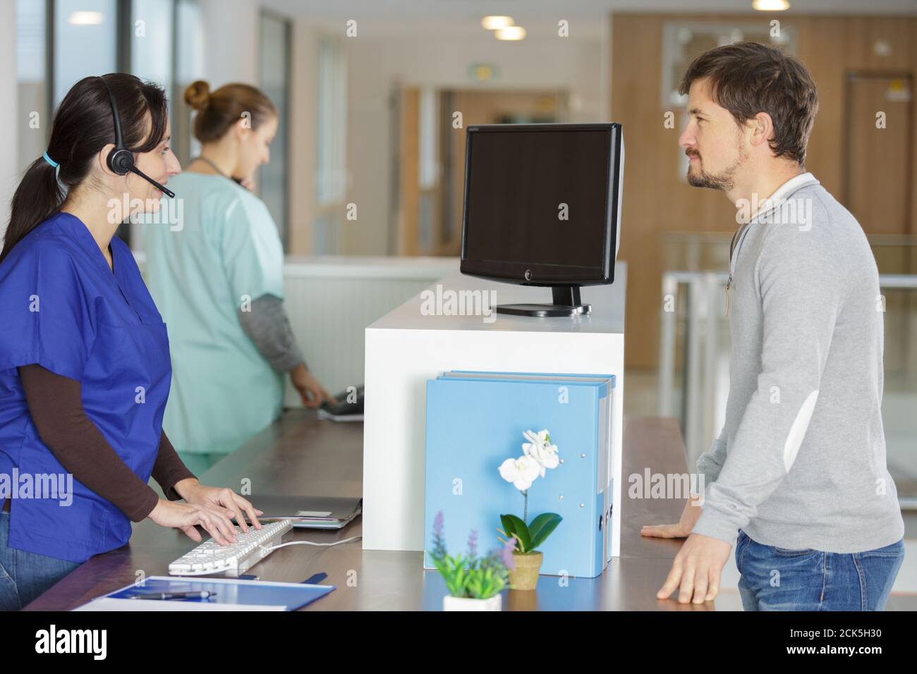 male patient with doctor at reception desk in hospital Stock Photo - Alamy