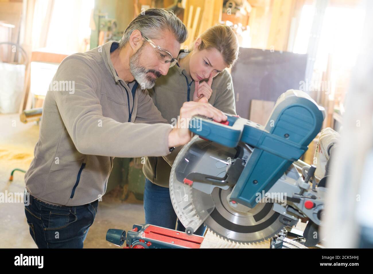 man and female trainee preparing wood plank in printing workshop Stock ...