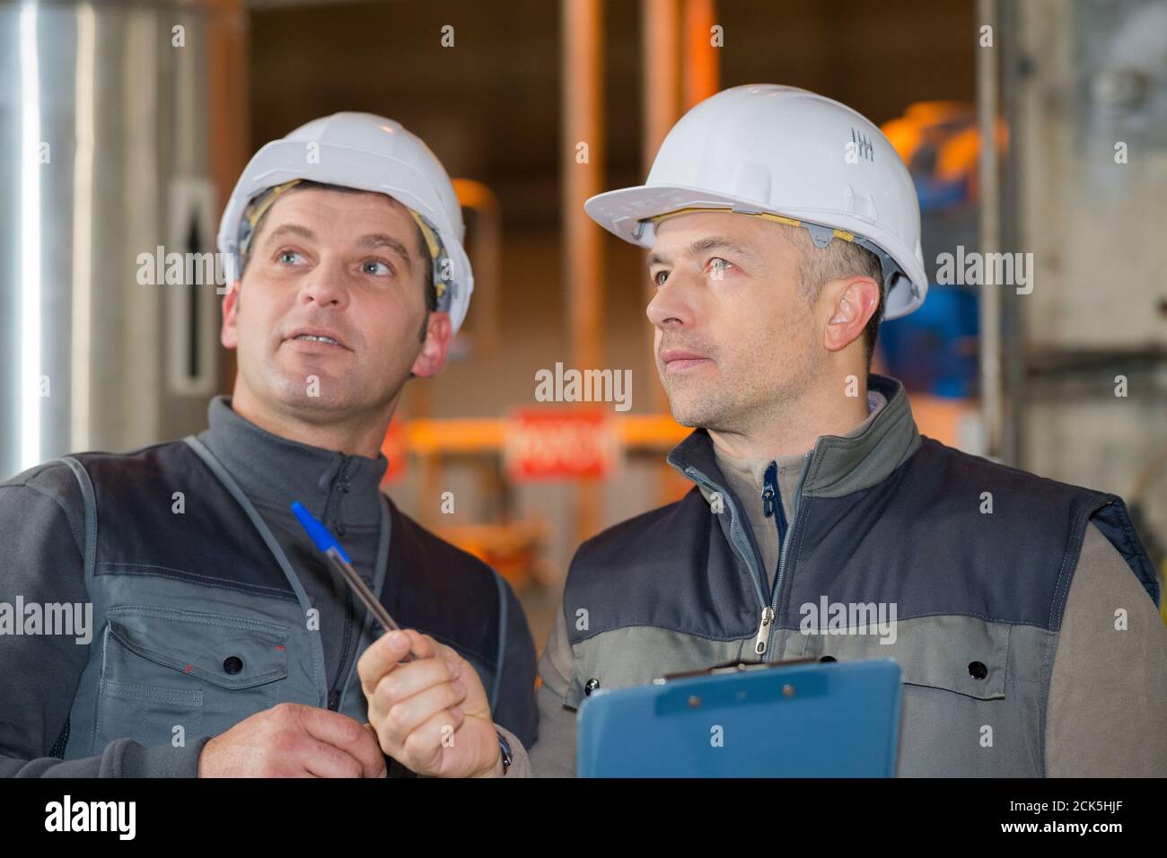 two engineers with clipboard on site visit Stock Photo - Alamy