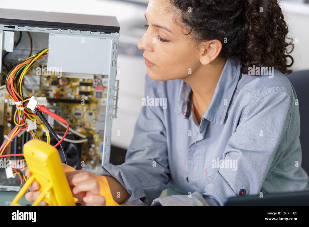 female technician using voltage meter for measuring a pc Stock Photo ...