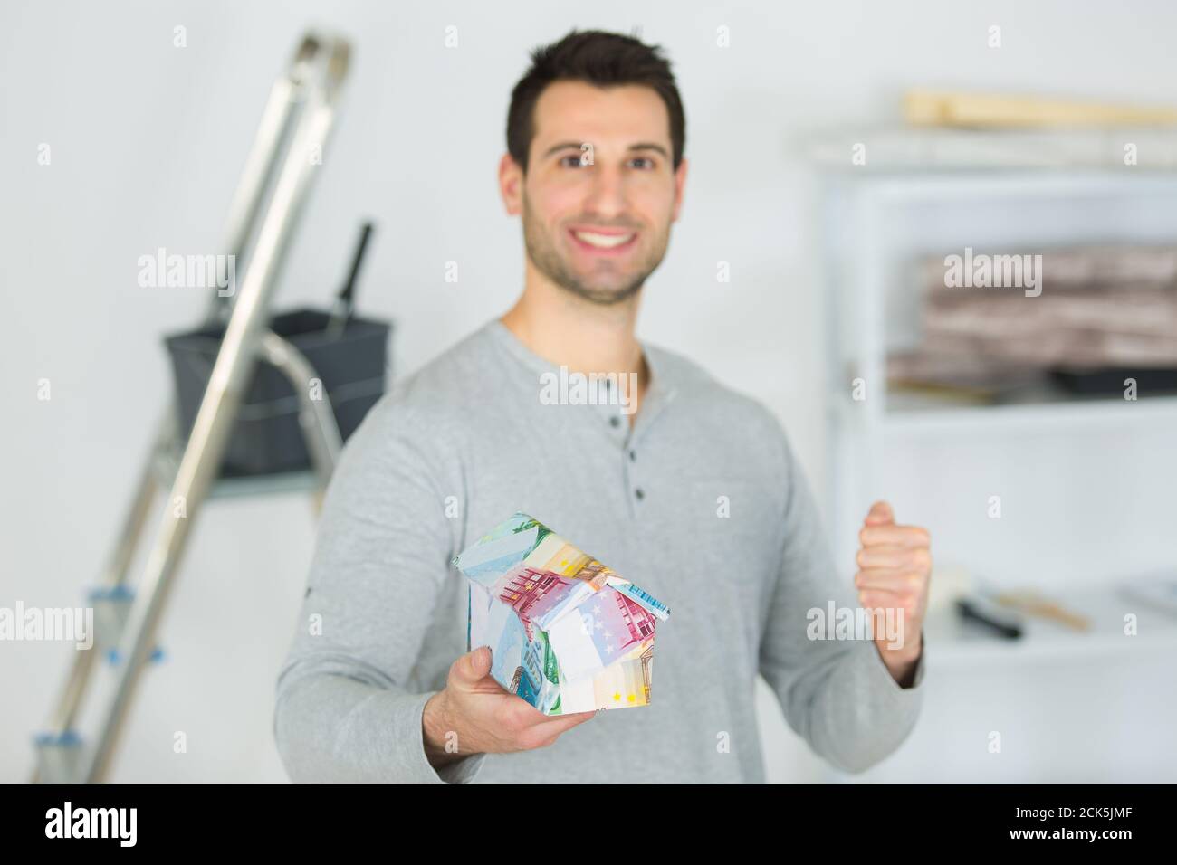 man holding a dummy of a house in his hands Stock Photo - Alamy