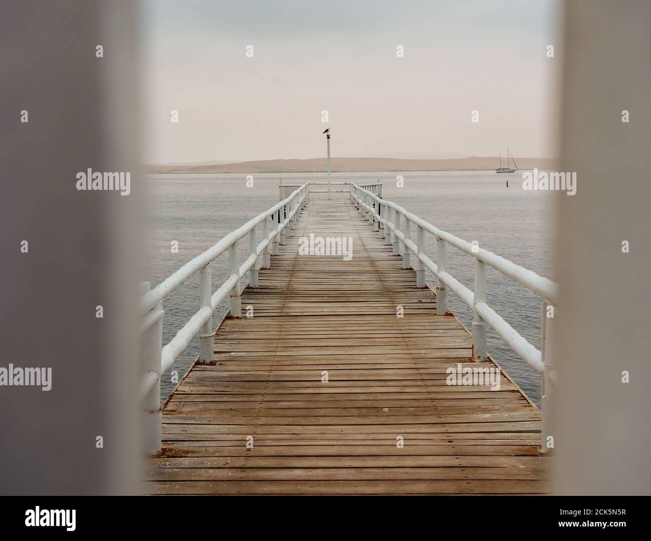 Long wooden dock leading into the water Stock Photo - Alamy