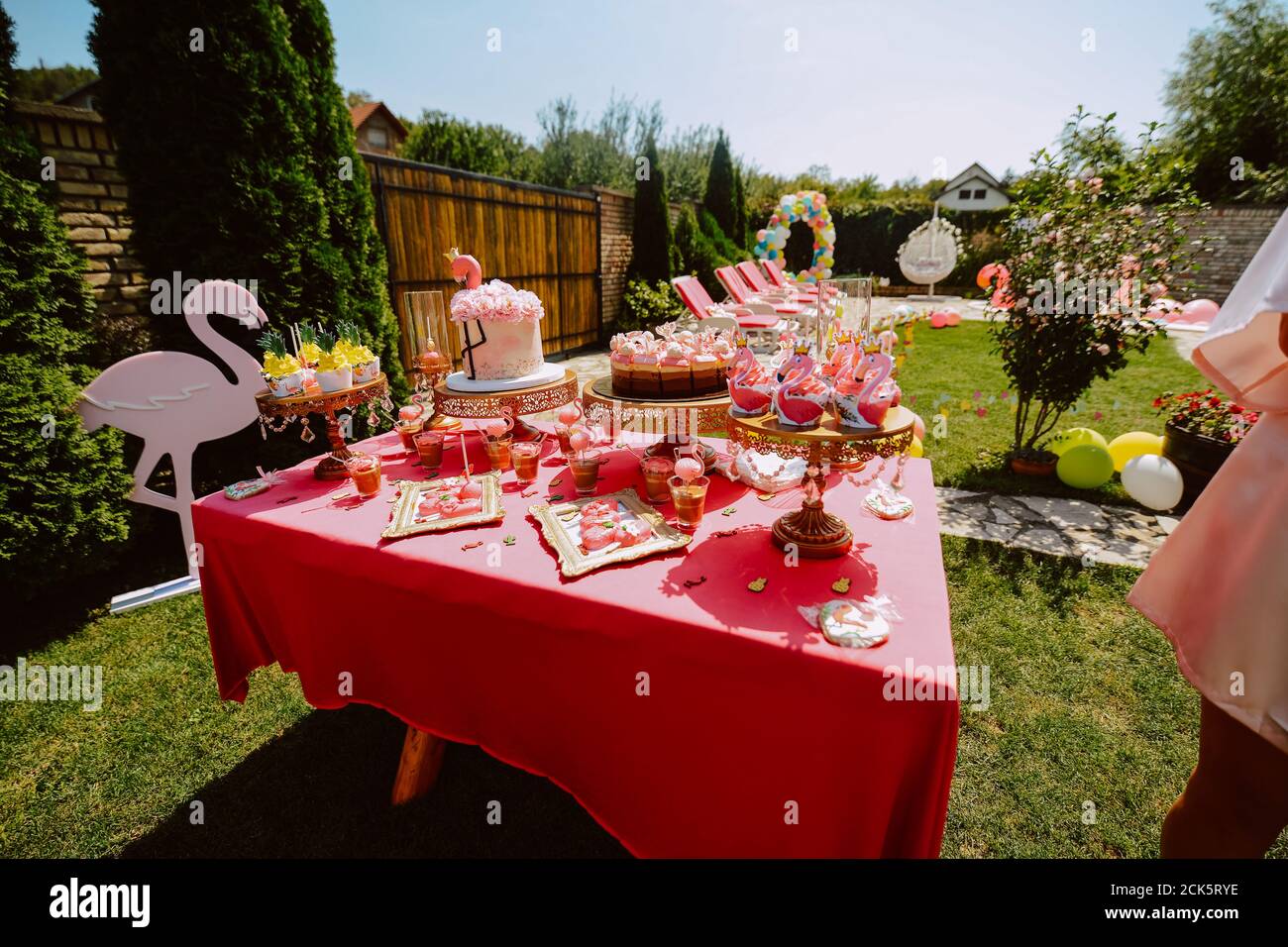 Cute pink table for a summer party in the yard. Pink cakes and treats ...