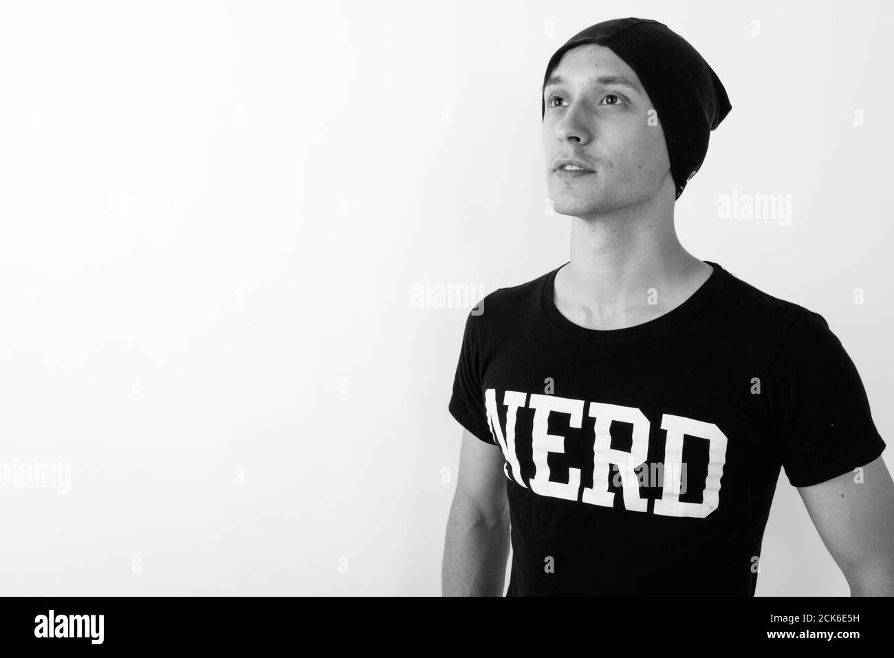 Studio shot of young handsome nerd man thinking and looking up while ...