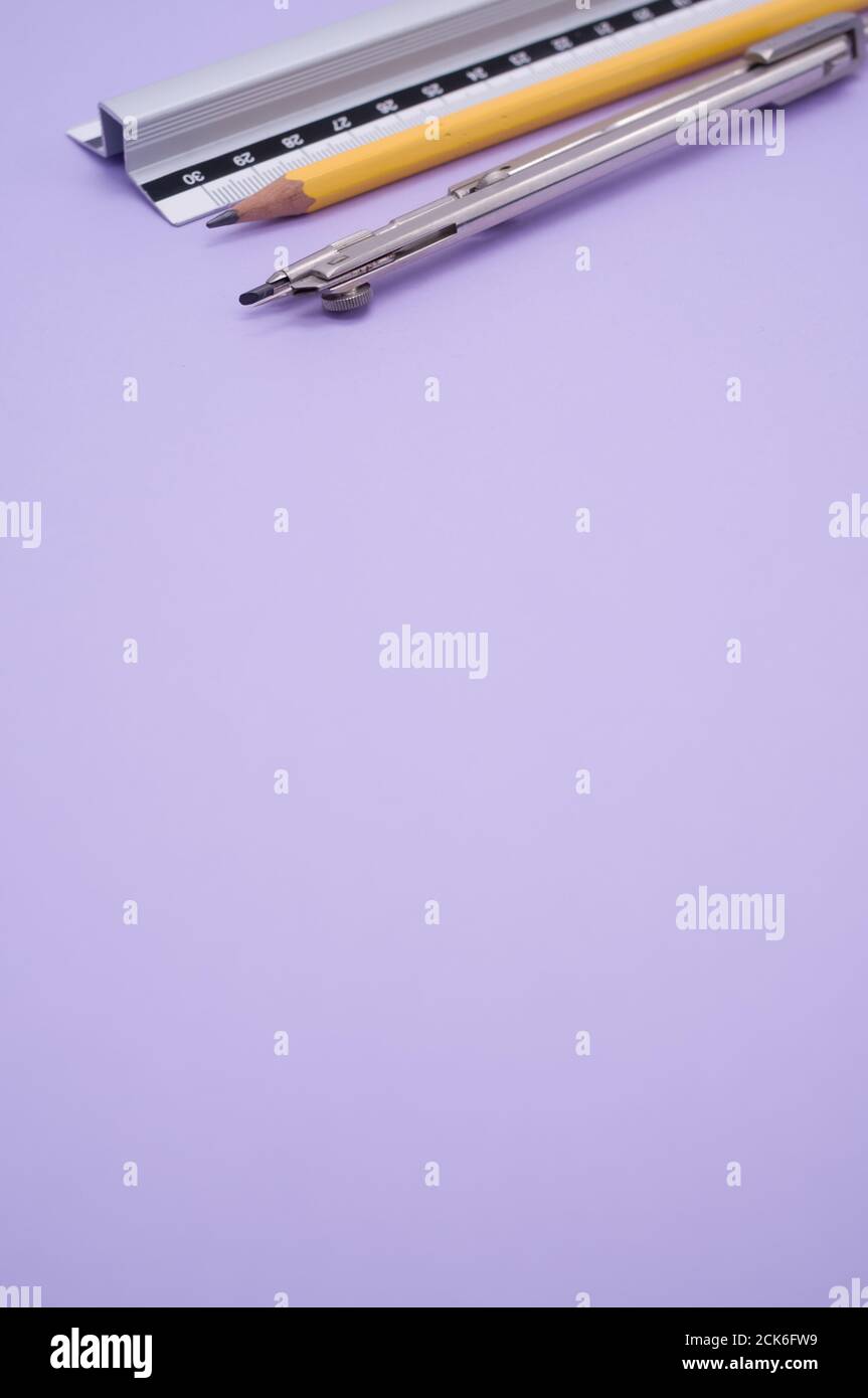 Vertical shot of a set of technical drawing tools on a purple ...