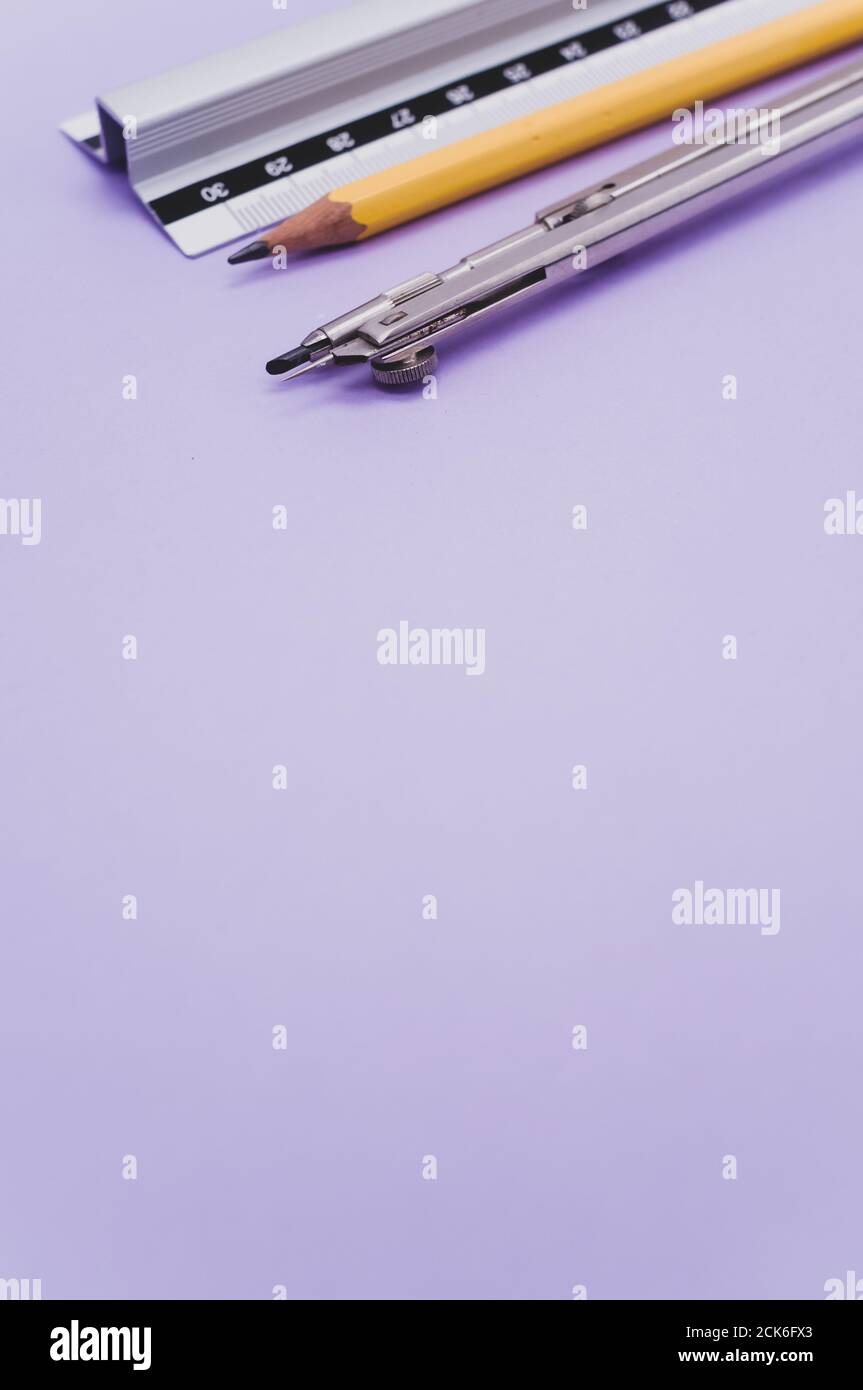 Vertical shot of a set of technical drawing tools on a purple ...