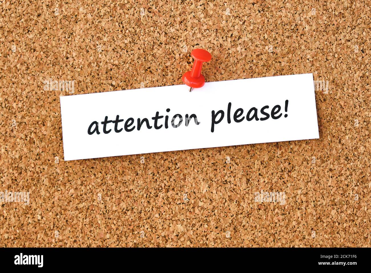 Attention please. Text written on a piece of paper or note, cork board ...