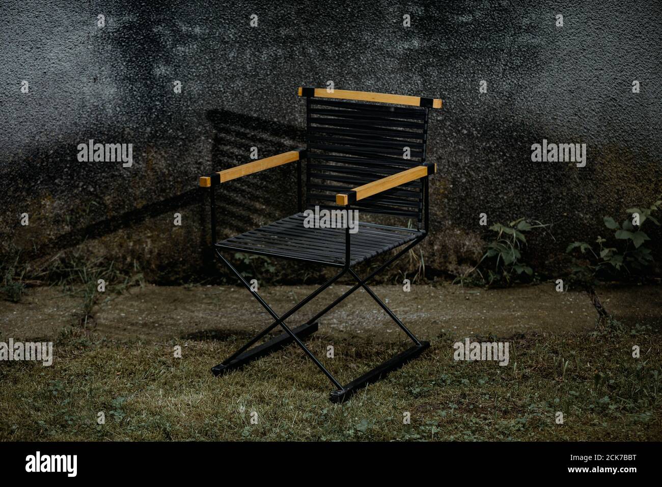 Closeup of a director's black chair, chair shadow on the back wall ...