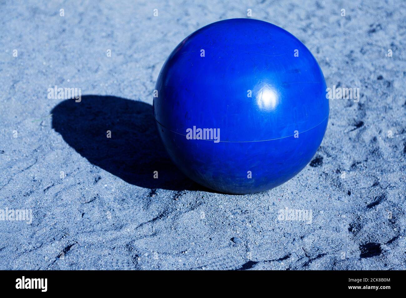 a large metal ball in blue sand Stock Photo - Alamy