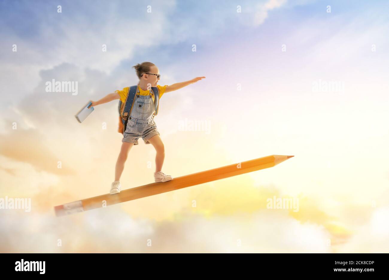 Back to school! Happy cute industrious child flying on the pencil on ...