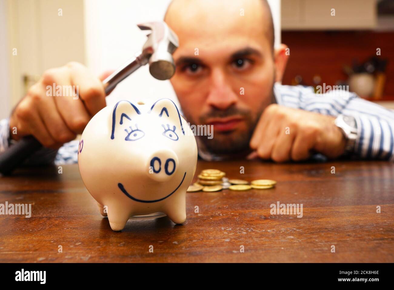 Man about to break a piggy bank Stock Photo - Alamy