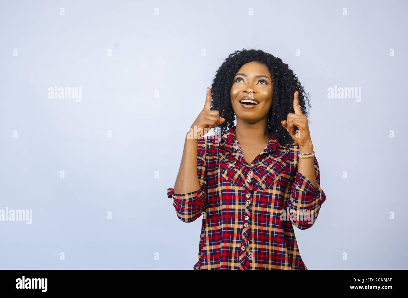 Overexcited African female pointing upward with her fingers Stock Photo ...