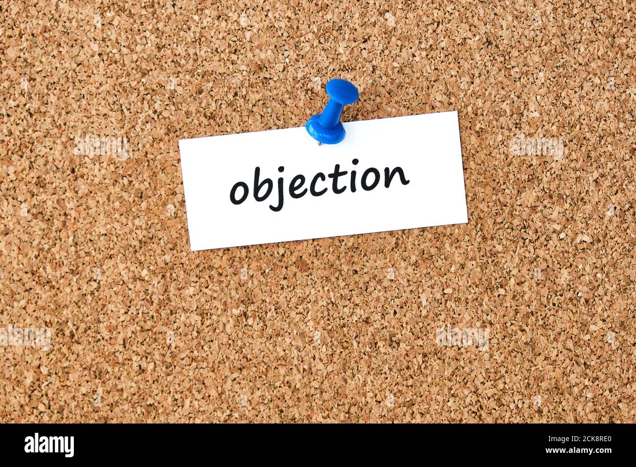 Objection. Word written on a piece of paper or note, cork board ...