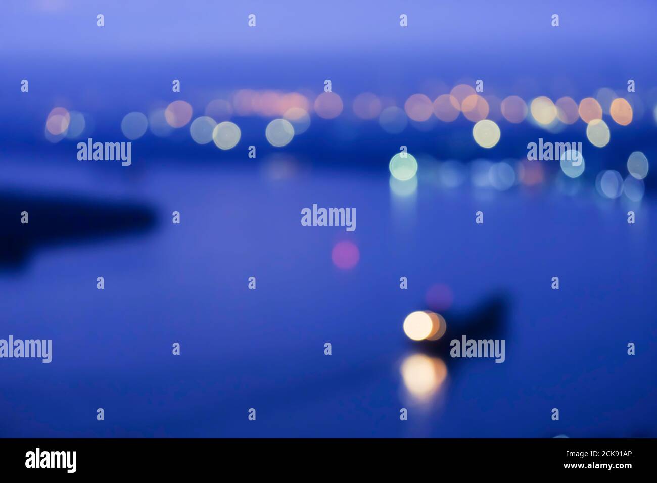 Defocus cityscape on a riverside at blue night, bright and colourful ...