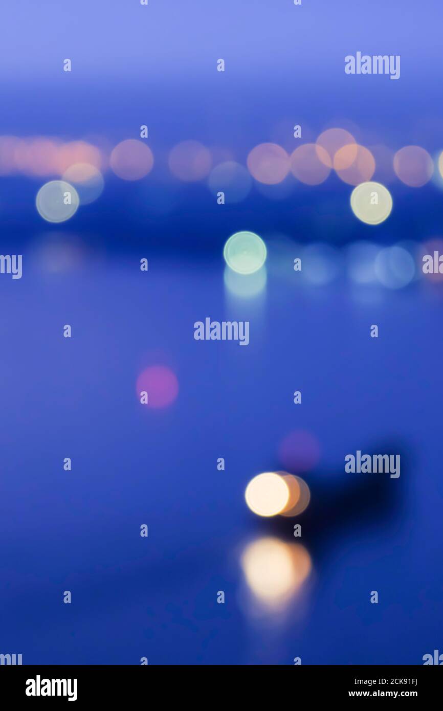 Defocus cityscape on a riverside at blue night, bright and colourful ...