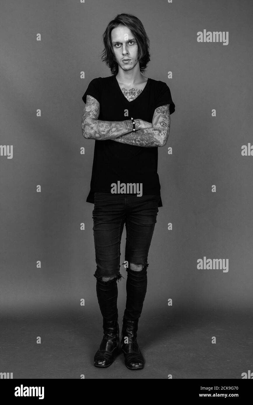Young handsome rebellious man against gray background Stock Photo - Alamy