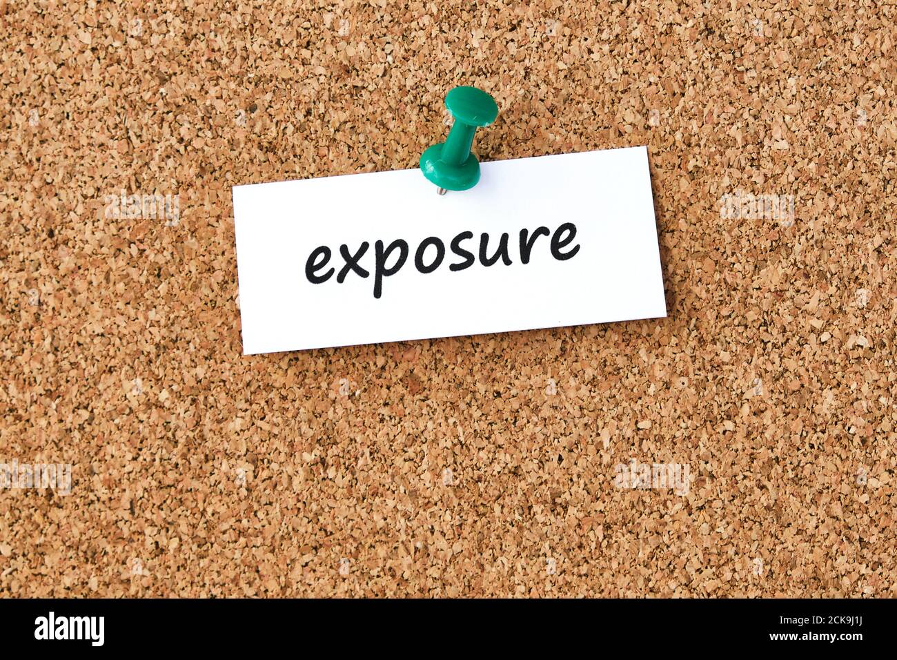 Exposure. Word written on a piece of paper or note, cork board ...