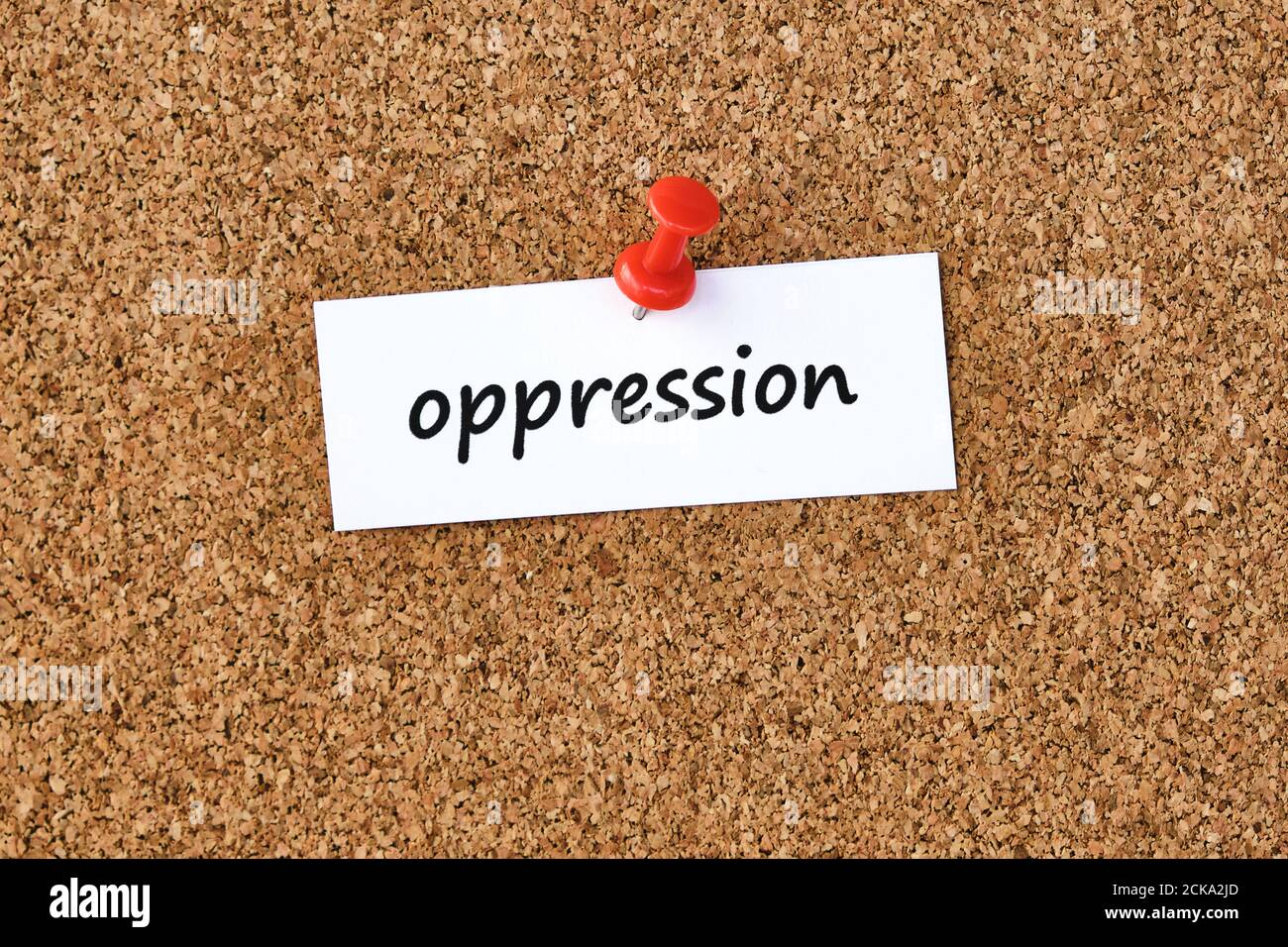 Oppression. Word written on a piece of paper or note, cork board ...