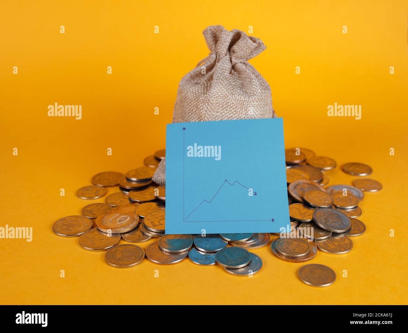 money bag with coins on a yellow background Stock Photo - Alamy
