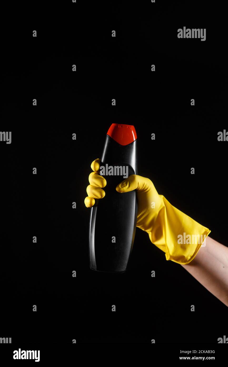 cleaning products, black rust remover in hands with yellow rubber ...