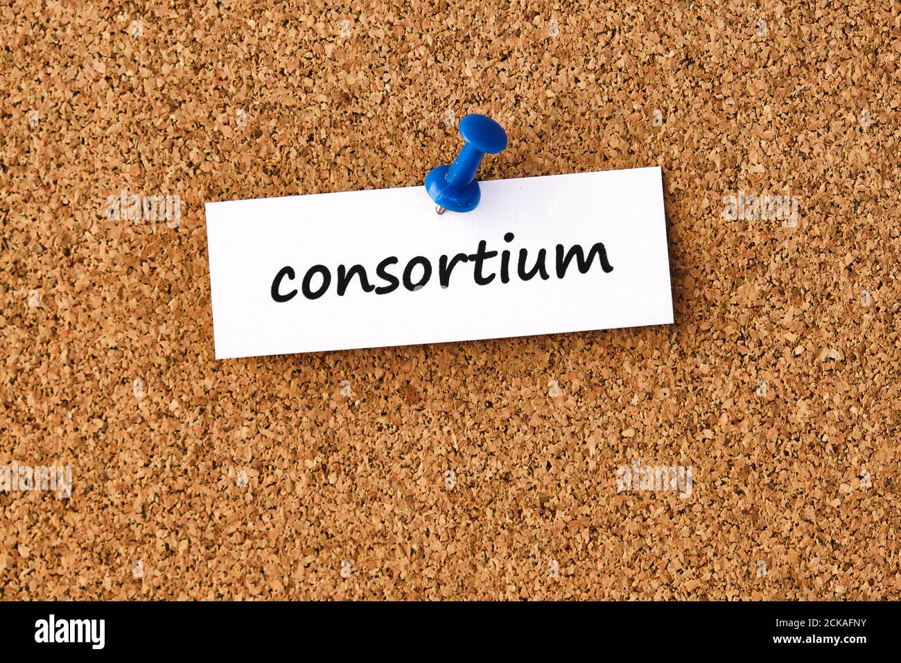 Consortium. Word written on a piece of paper or note, cork board ...