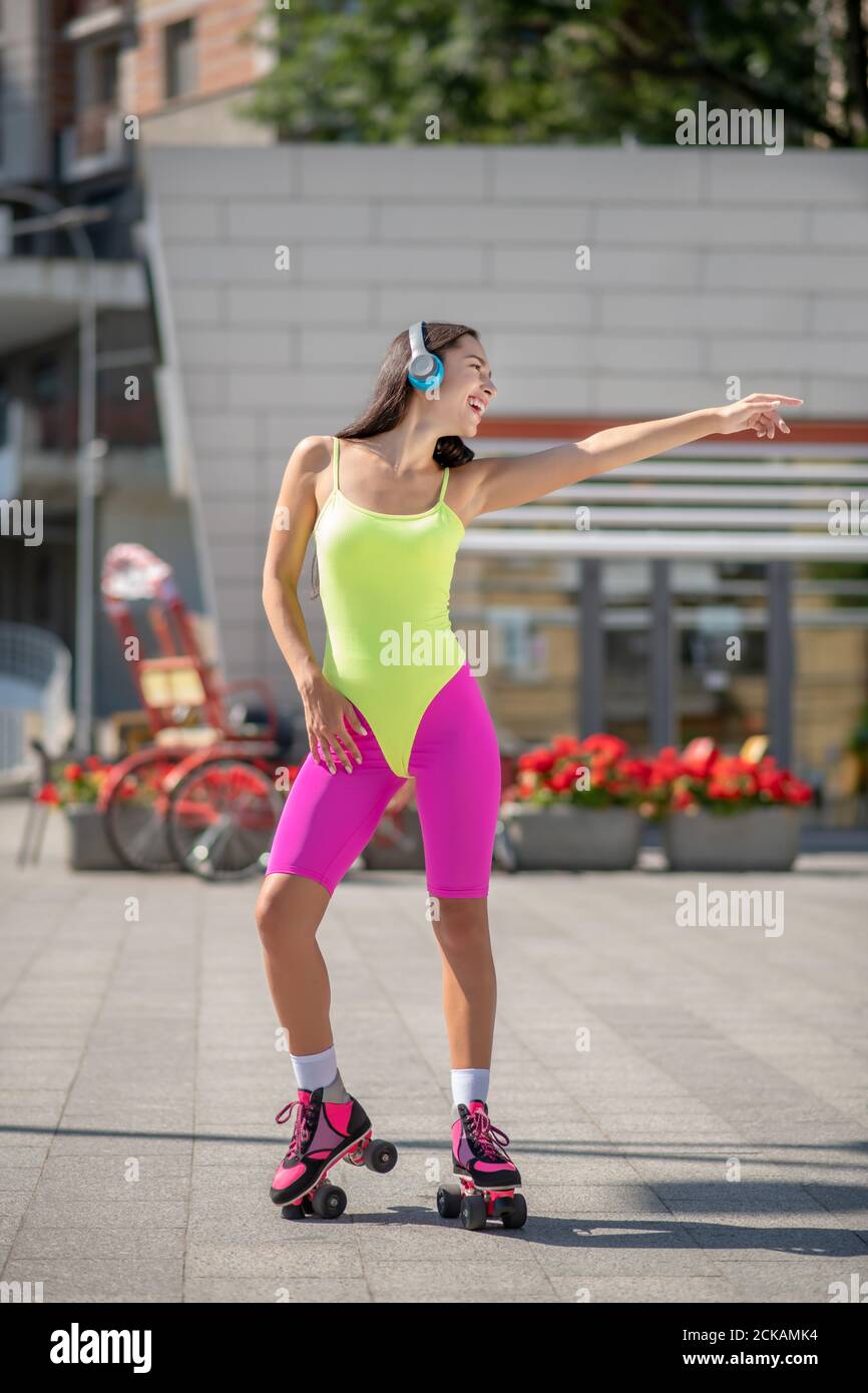Girl in bright sportswear and roller-skates dancing Stock Photo - Alamy