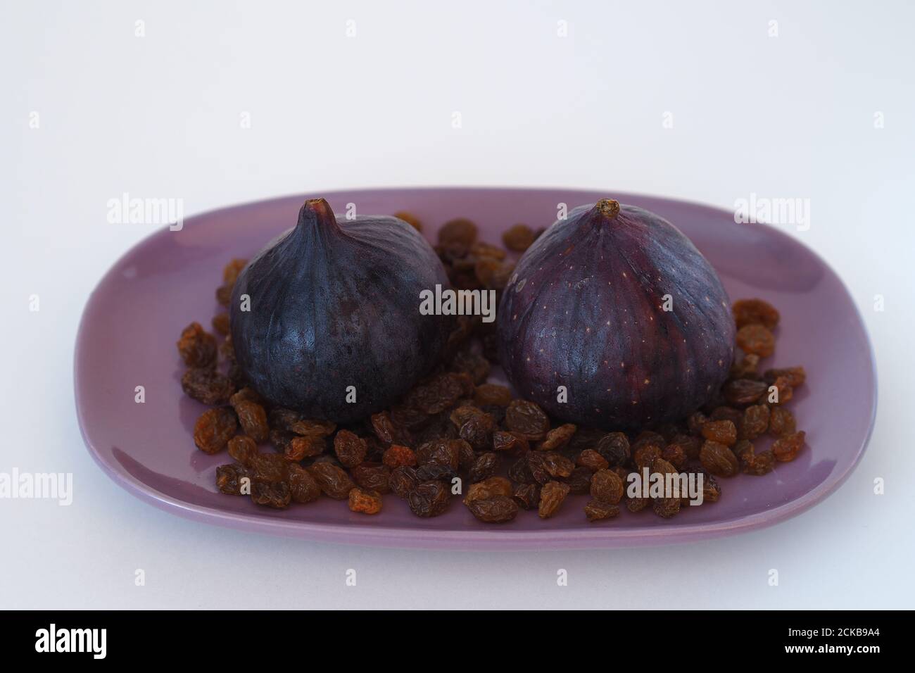 Fruit. Fig and raisins on a platter. White background Stock Photo - Alamy